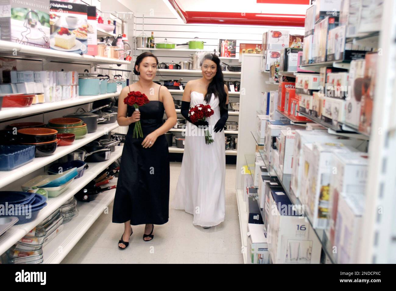 Self-proclaimed "Maxxinista" Bride Lisa Satayut (R) walks down an aisle ...