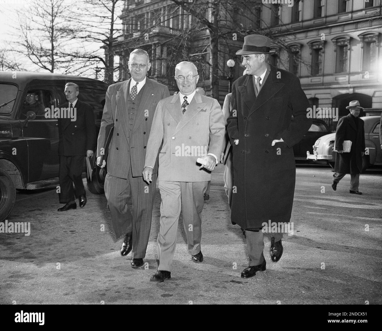 President Harry Truman walks with John R. Steelman, left, and W ...
