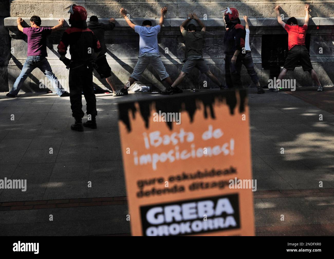 Several demonstrator are frisked as they lift their arms on a wall as ...