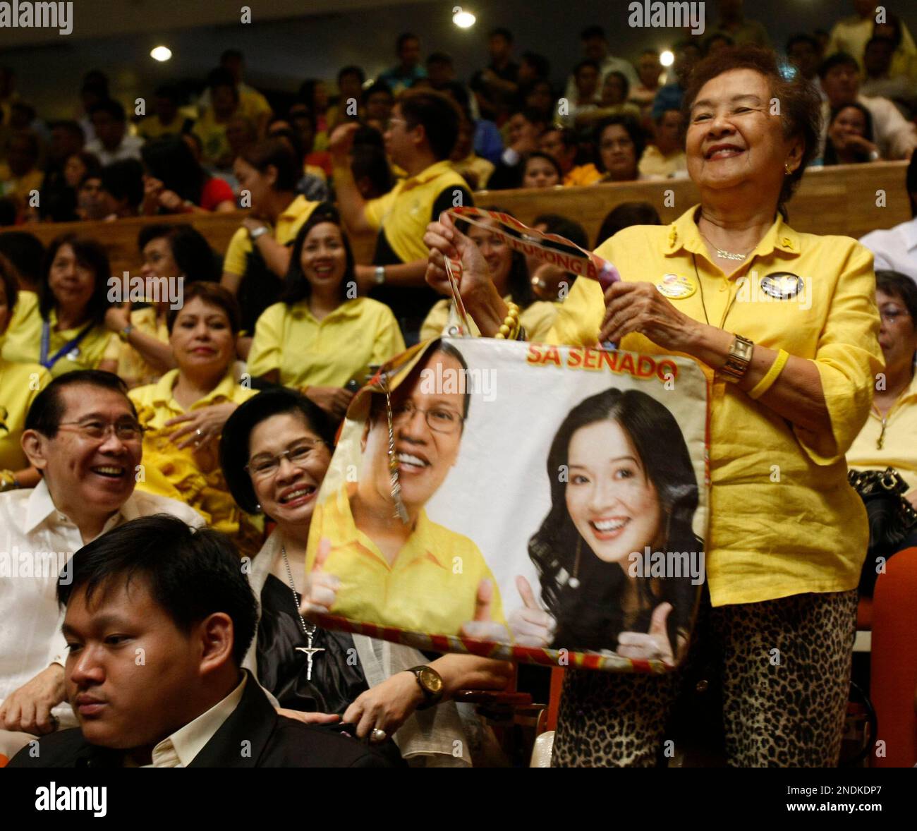 A supporter displays her handbag with portraits of Philippine President-elect Benigno Aquino III ...
