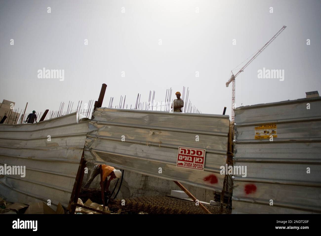 Construction workers are seen on a new housing development in the ...