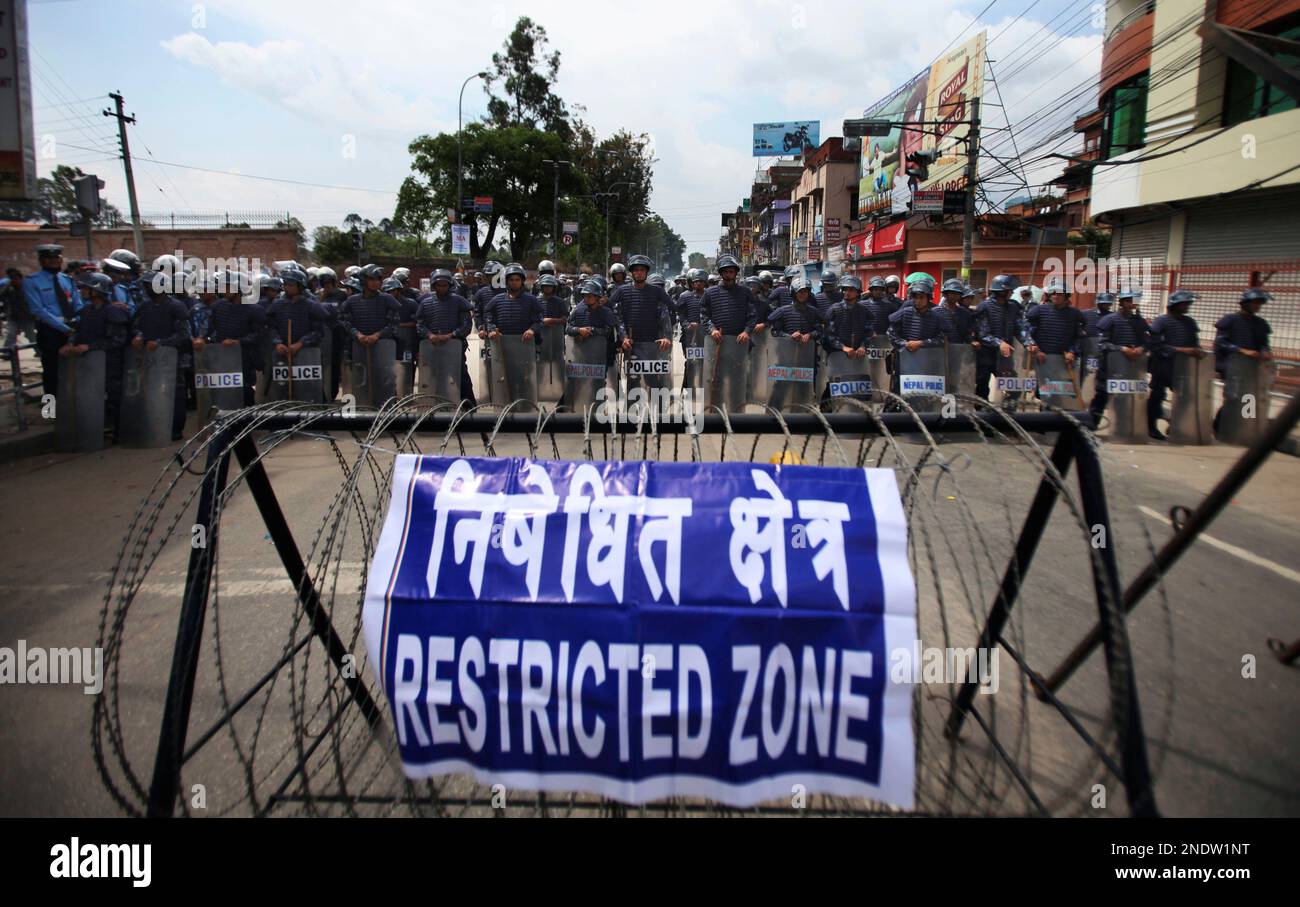 Nepalese police in riot gear stand guard near a barricade during an ...