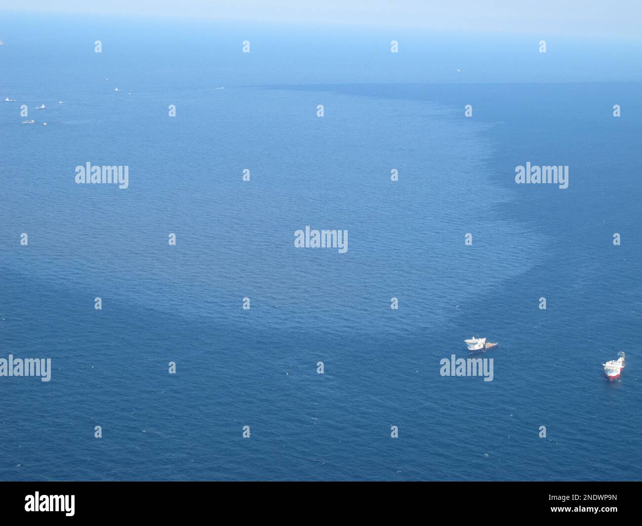 Two ships float near in a massive oil slick spreading in the Gulf of ...