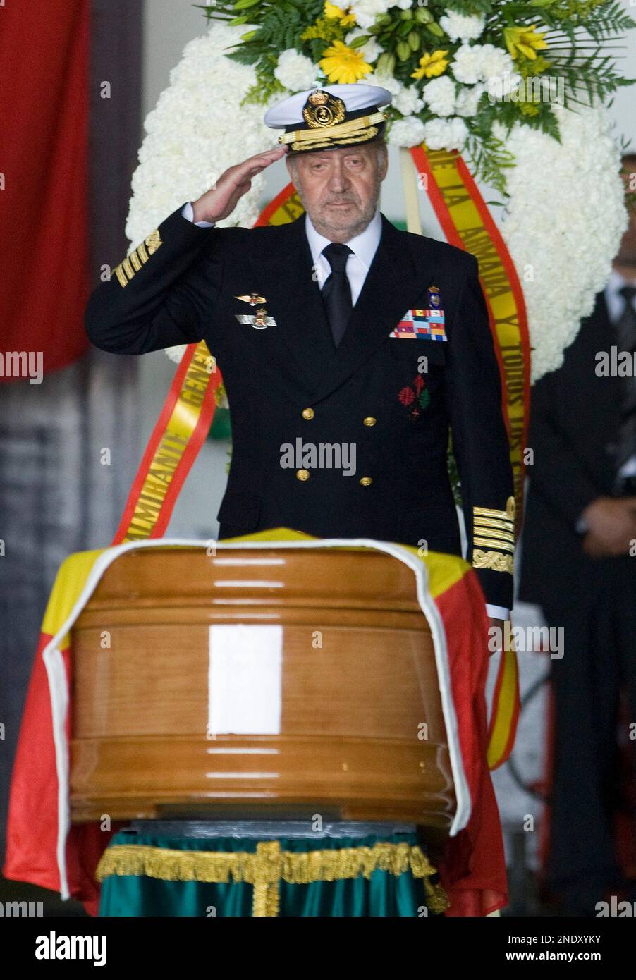 Spain's King Juan Carlos salutes in front of the casket of one of four ...