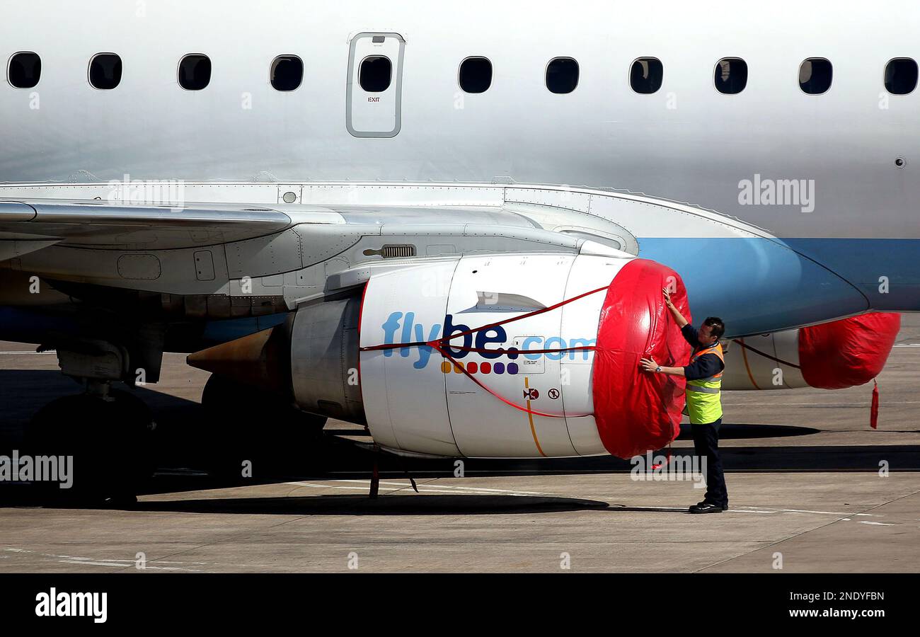 A aircraft maintenance worker covers a jet engine at Belfast City ...