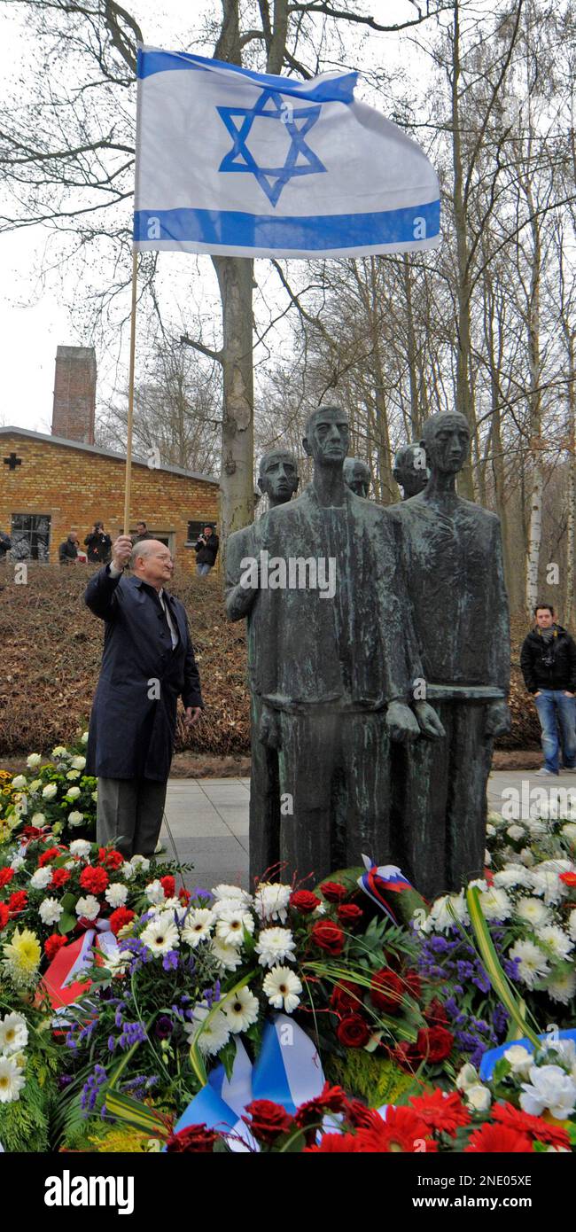 Nazi concentration camp survivor Izchak Doveh of Israel holds a Jewish flag besides the memorial ...