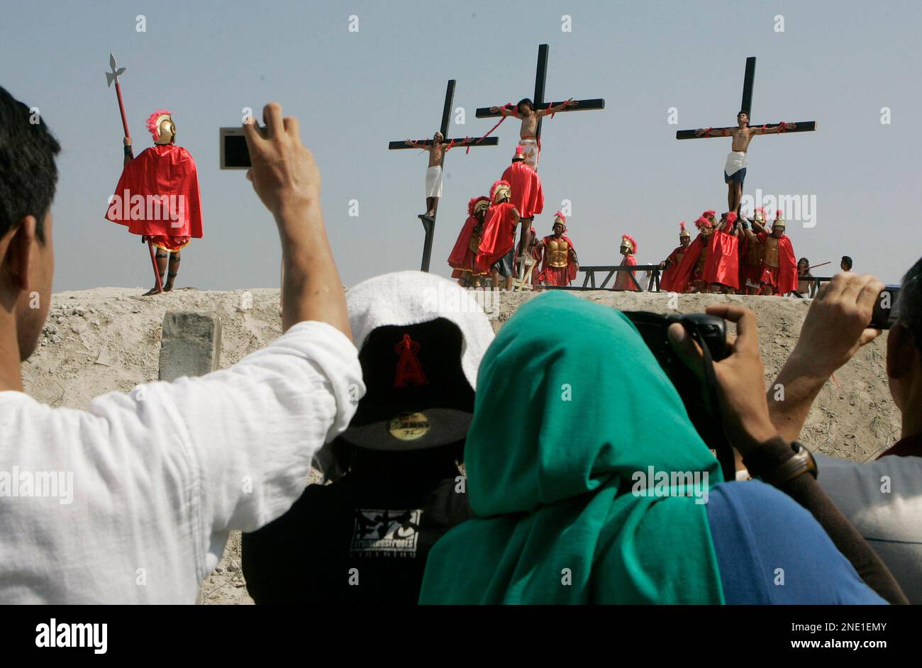 Filipinos look at penitents that are nailed to a cross during yearly ...