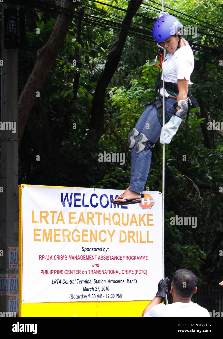 An elevated train passenger is lowered down on a rope during an ...