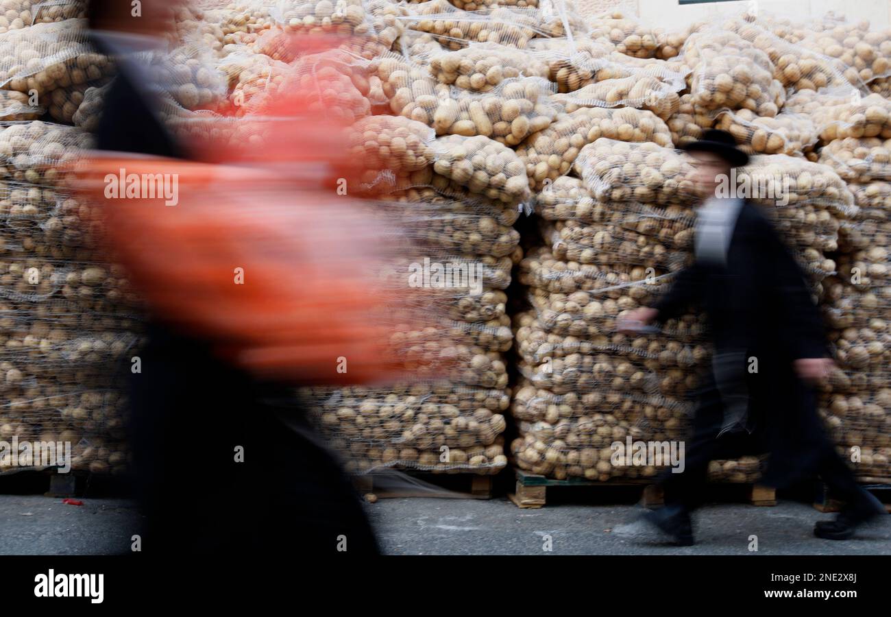 An Ultra-Orthodox Jewish man carries a bag of food as he walks past ...