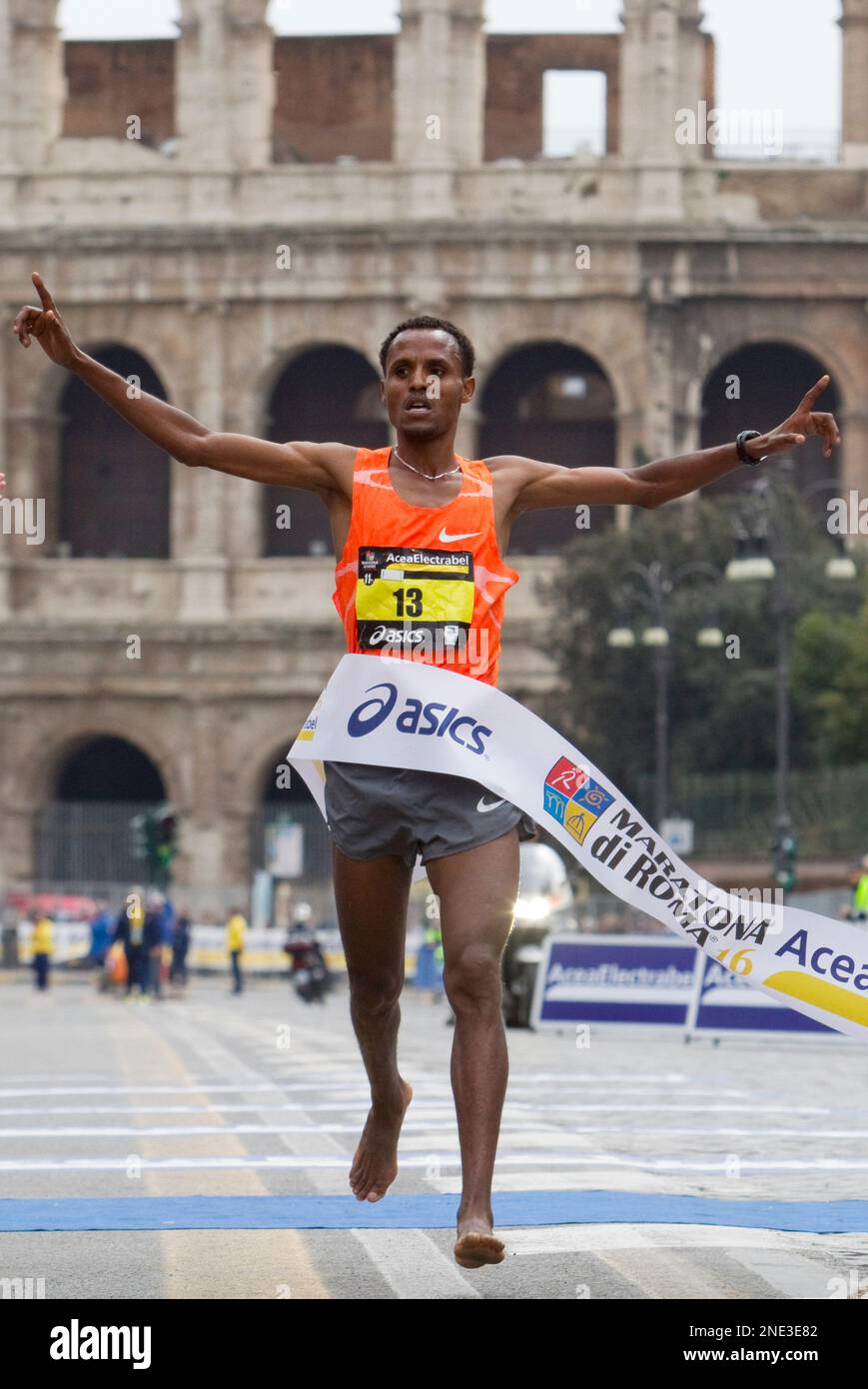 Siraj Gena of Ethiopia crosses the finish line bear foot in front of ...