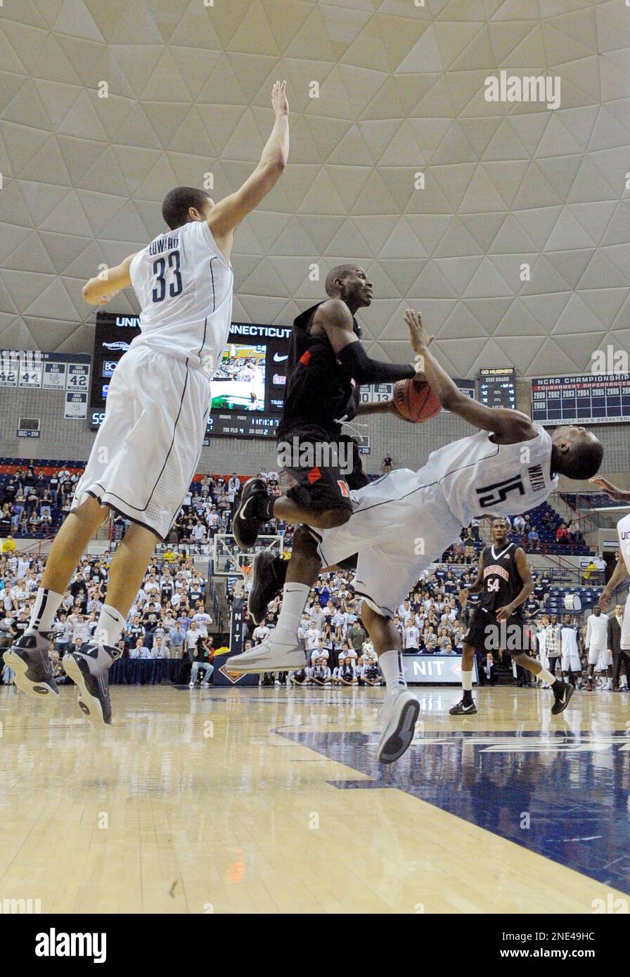 Northeastern's Chaisson Allen, center, drives to the hoop while being ...