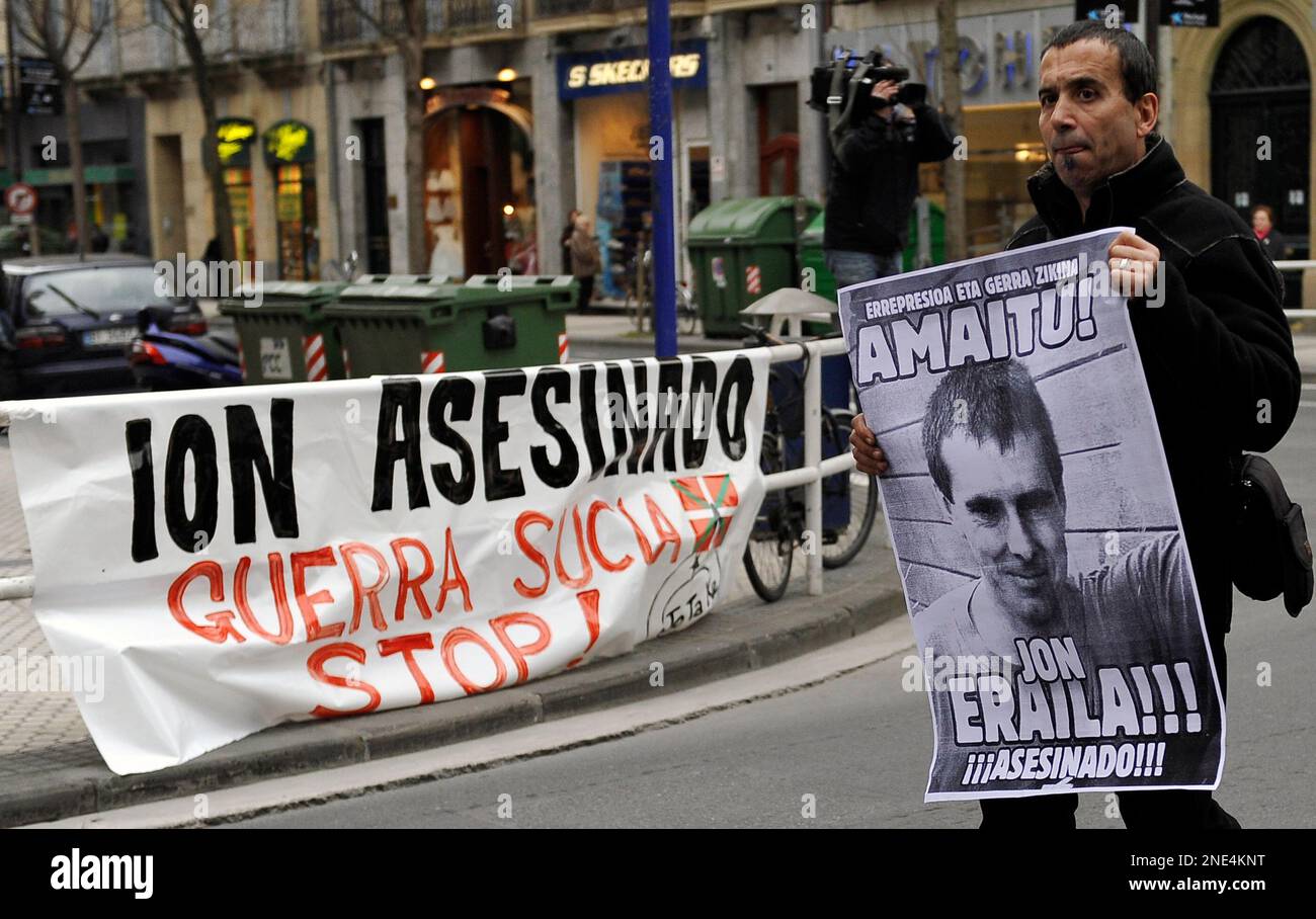 Basque pro independence supporter holds a portrait of Jon Anza, a ...