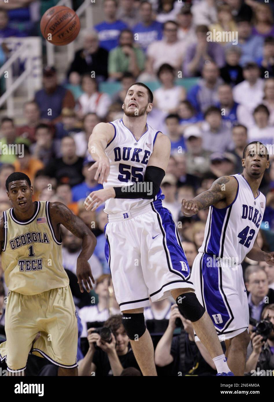 Duke's Brian Zoubek (55) makes a pass up court as Lance Thomas (42) and Iman Shumpert (1) look ...