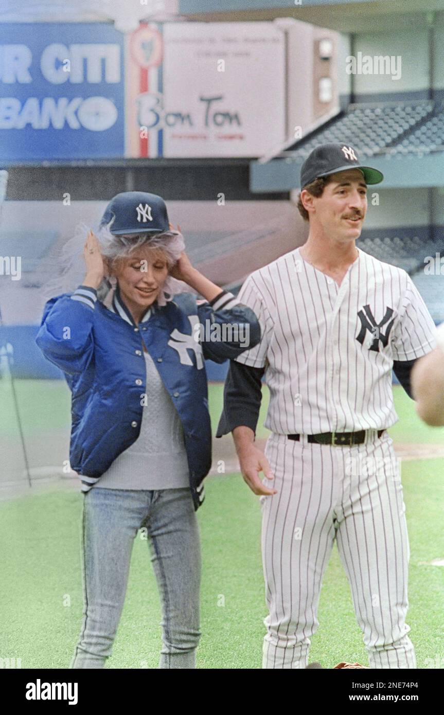 Actress Dolly Parton puts on a baseball hat during a visit with New ...