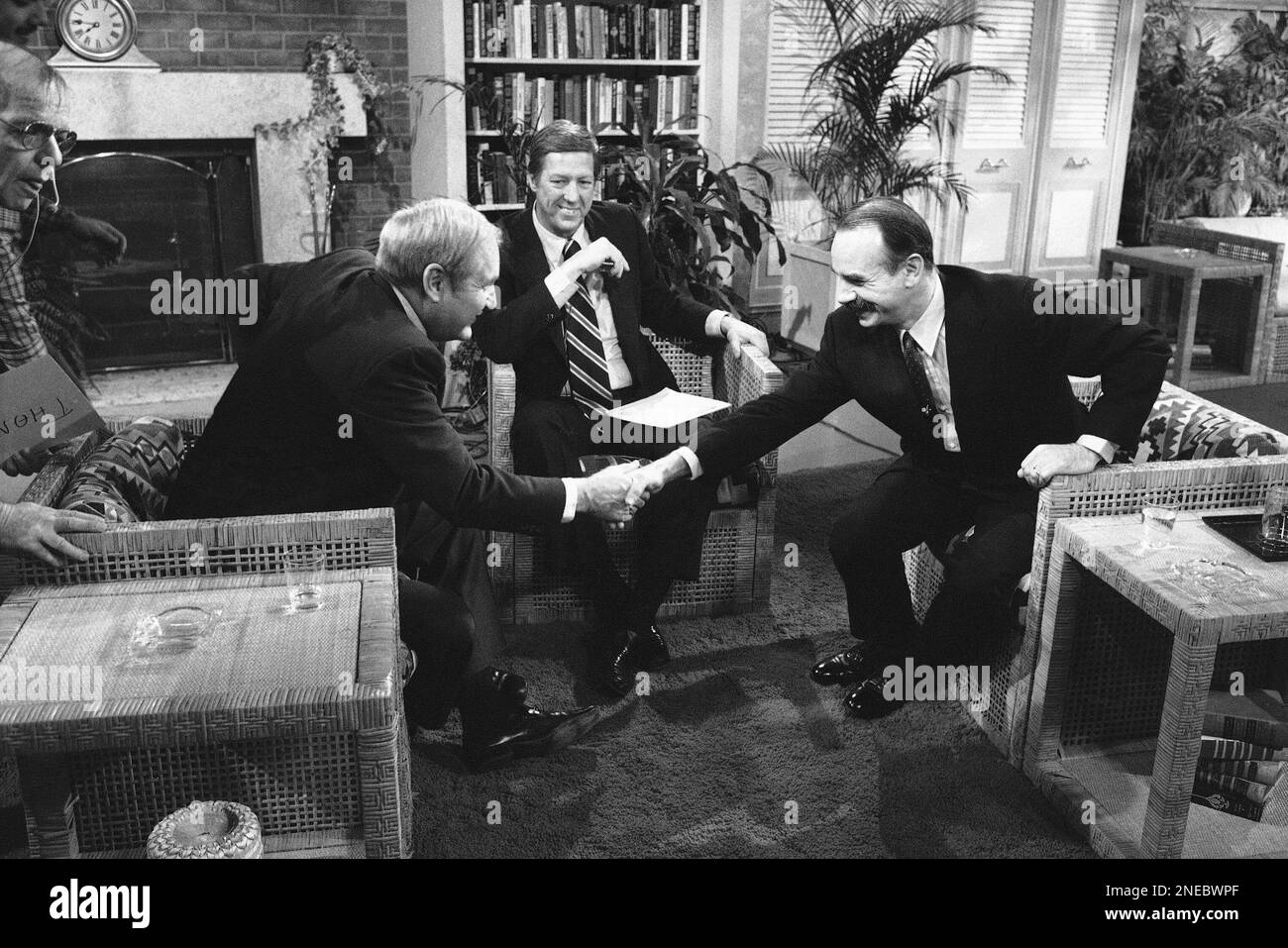 Mustachioed G. Gordon Liddy, right, of Watergate fame, leans over to ...