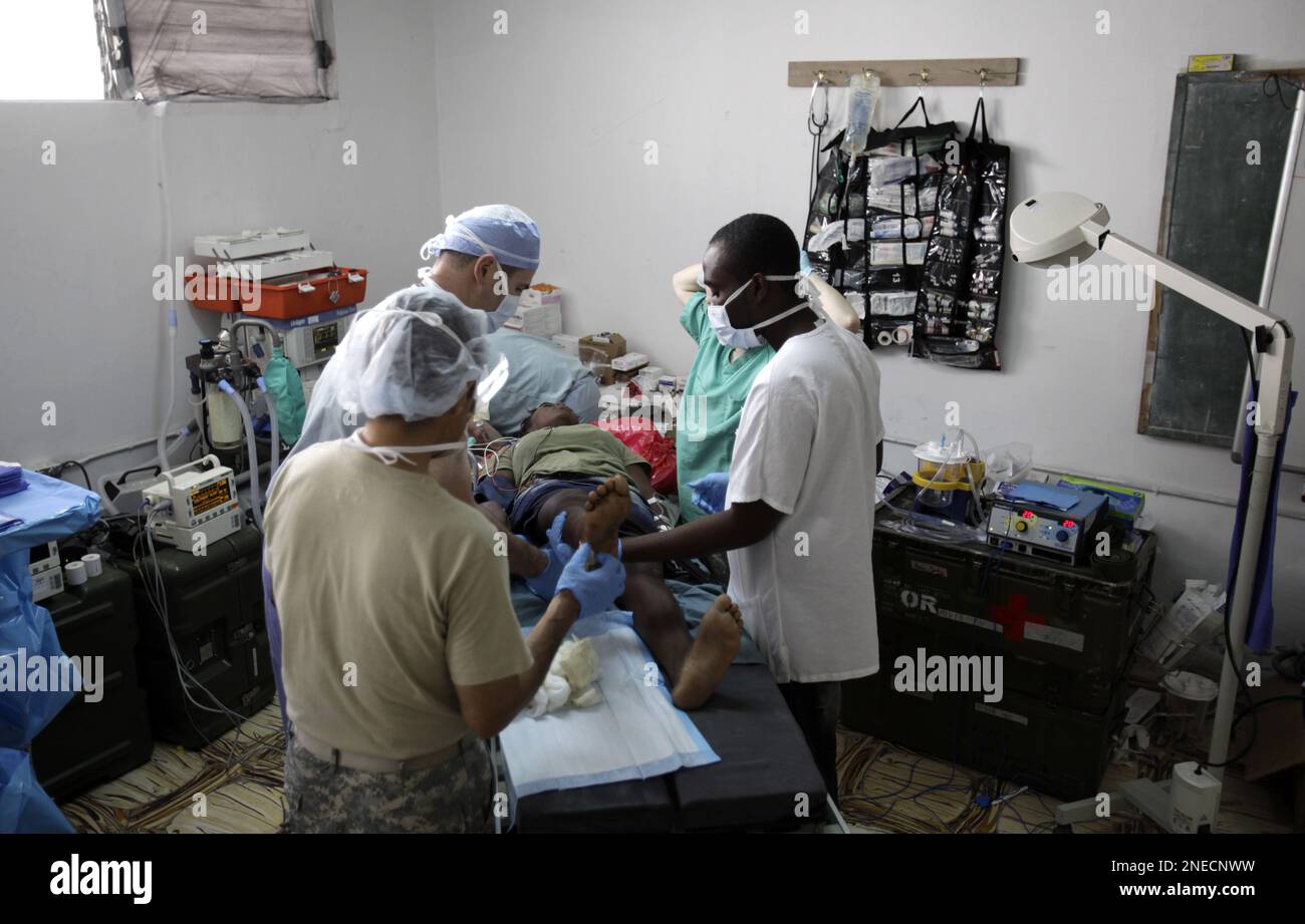 Doctors operate on a woman with an injured foot at the Killick Haitian ...