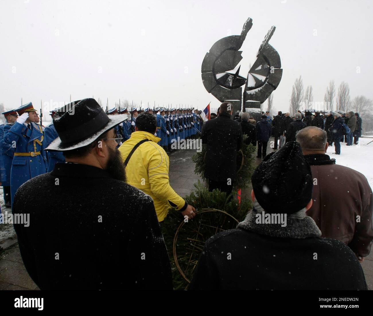 People pay homage to the victims of the Holocaust at a monument in ...