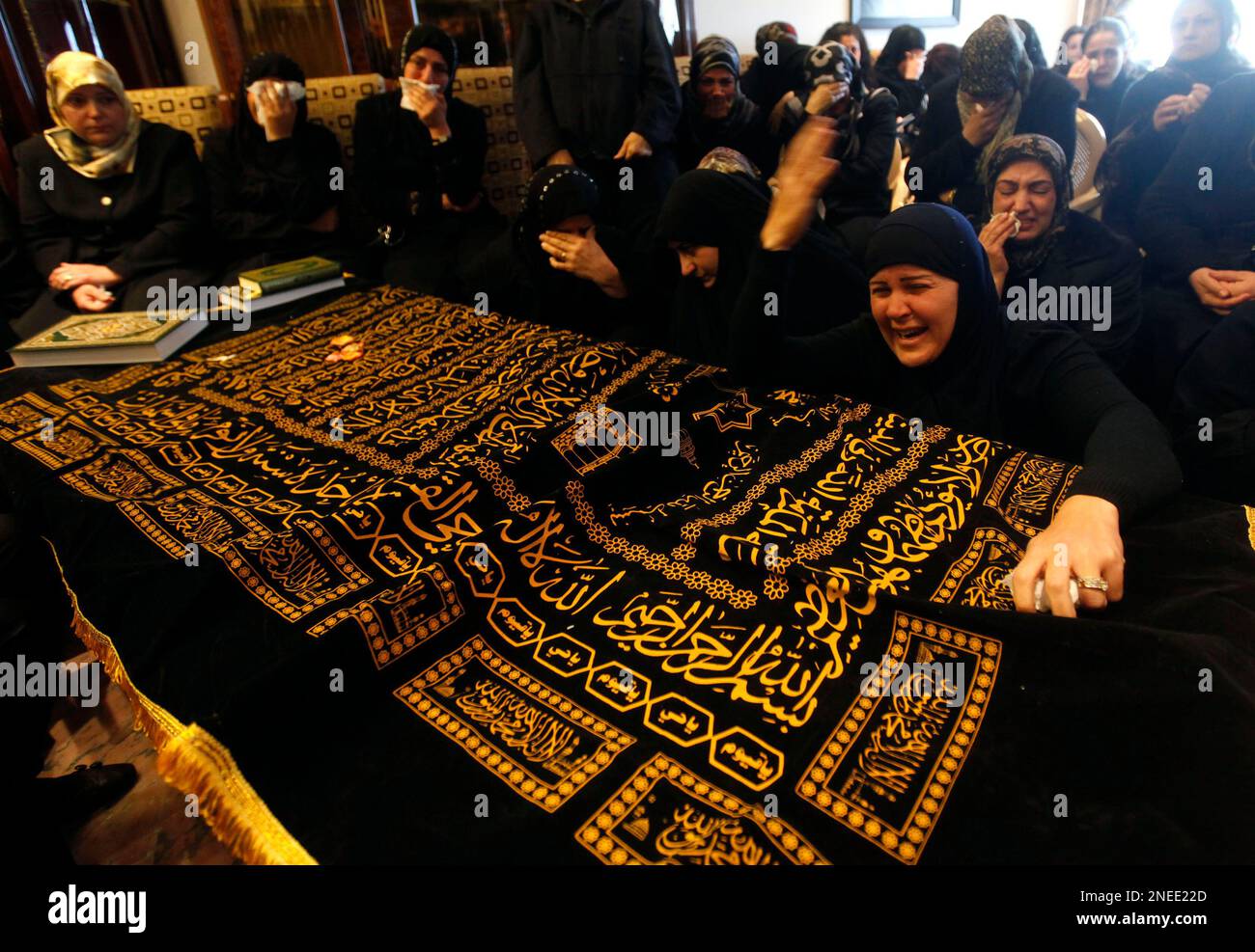Lebanese Nejmeh Tajeddine, right, mourns over the coffin of her husband ...
