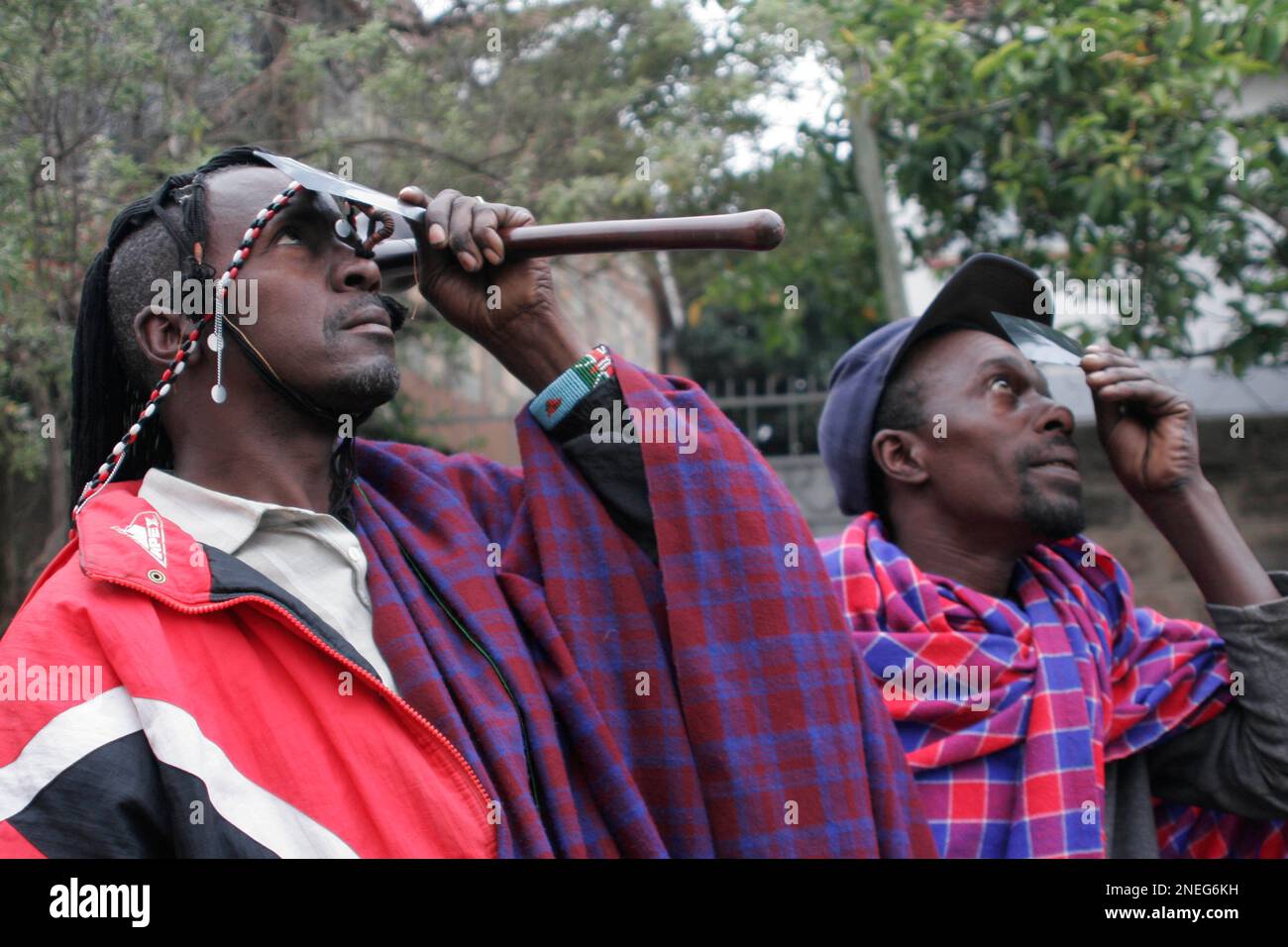 Kenyan Maasai tribesmen watch a solar eclipse through a x ray film in ...