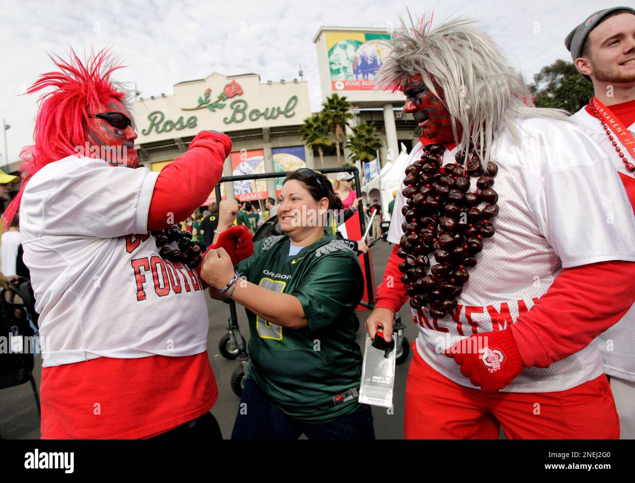 An Oregon fan jumps in the middle as Jim Lokai, left, and his brother ...