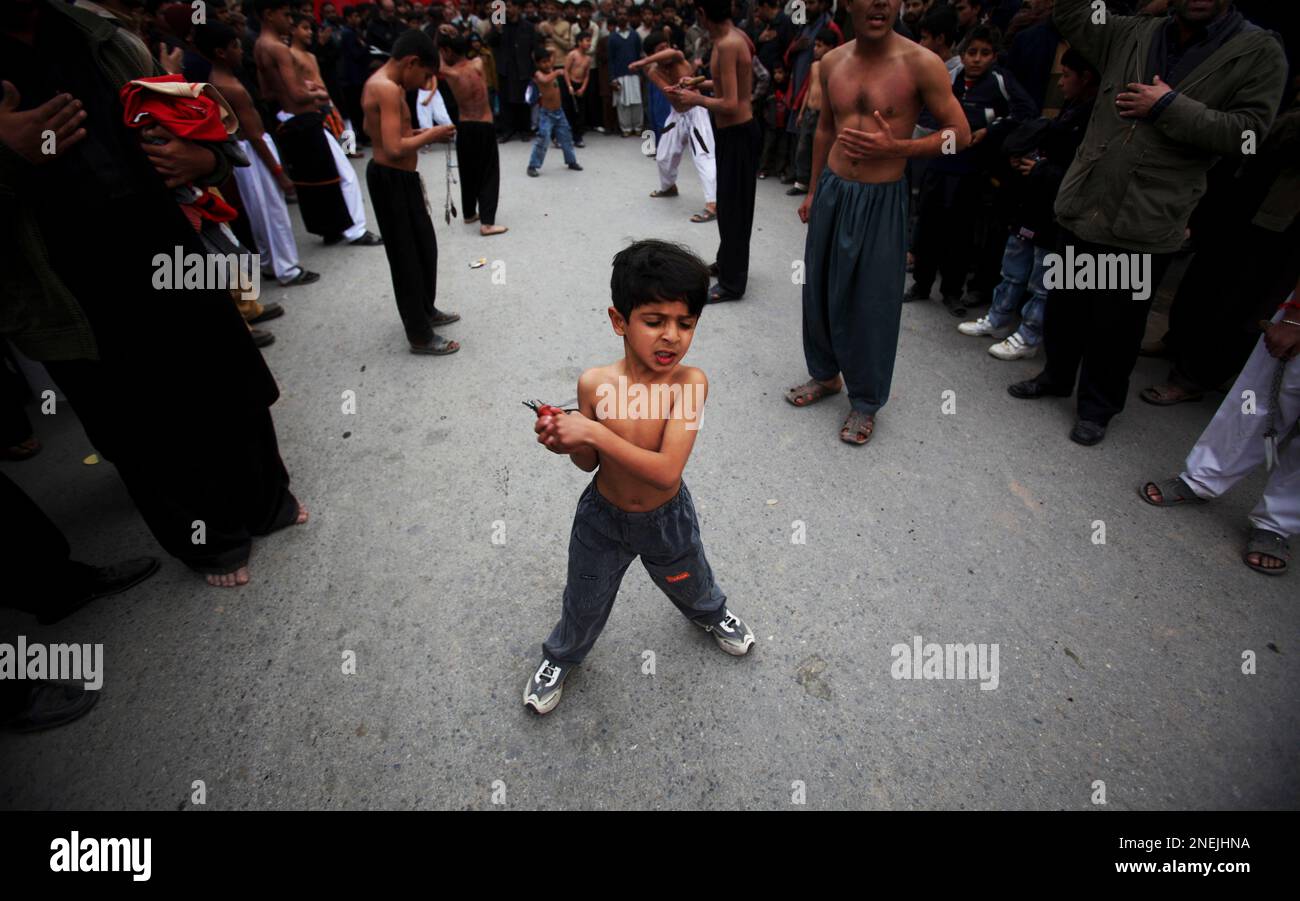 A Pakistani Shiite Muslim boy, beats himself with knives attached to a ...