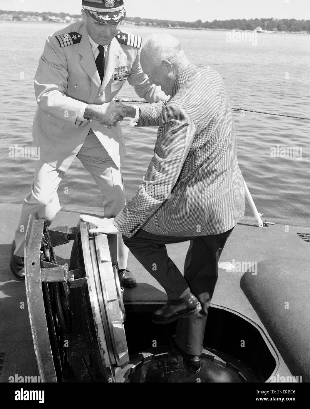 President Dwight Eisenhower gets an assist from Captain Harold E. Shear ...