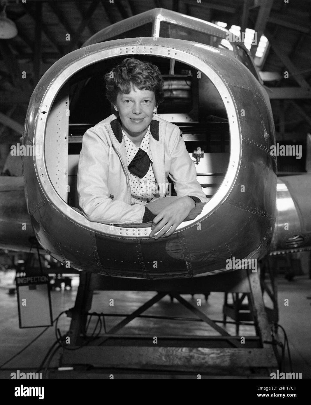Amelia Earhart, noted fier, inspected the Twin-Engined Lockheed Electra ...