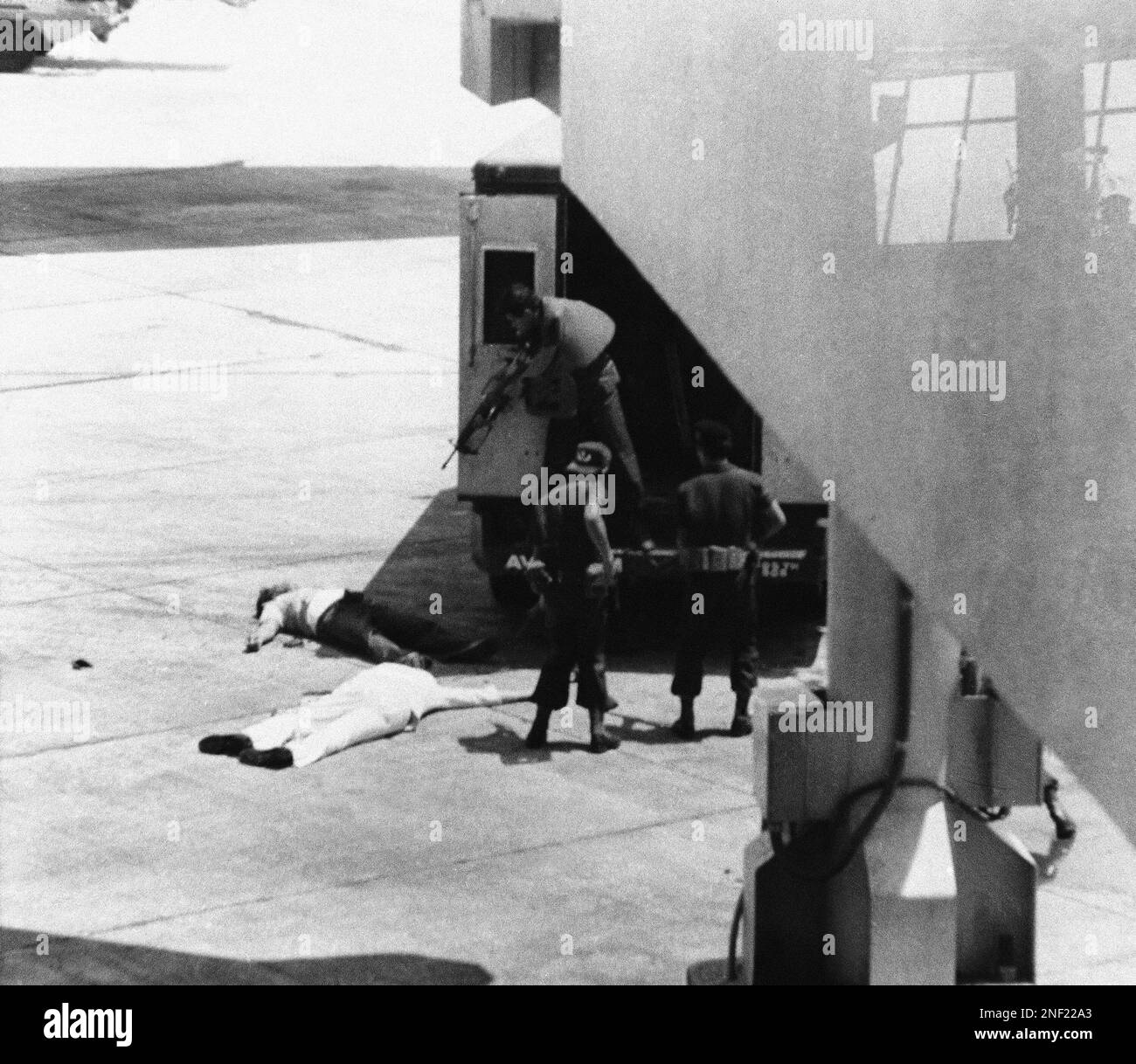 Airport security, in van, fires his M-16 rifle on the body of the ...