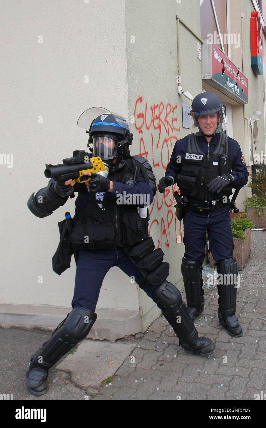 Riot police officers approach anti-NATO activists who set fire to an ...