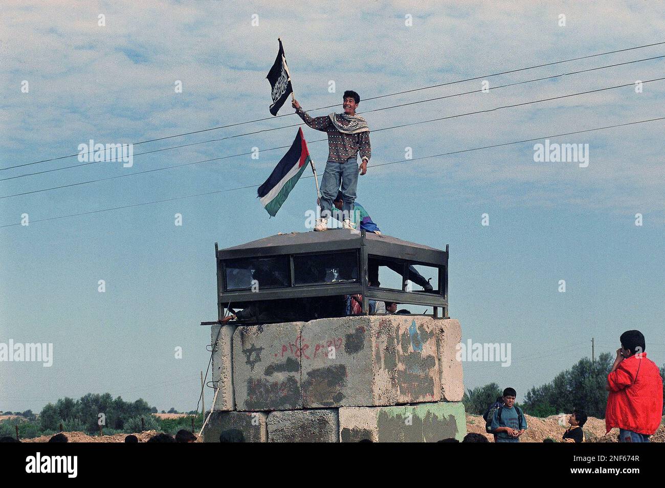 A Muslim activist hoists a Hamas flag atop an Israeli watchtower at a ...