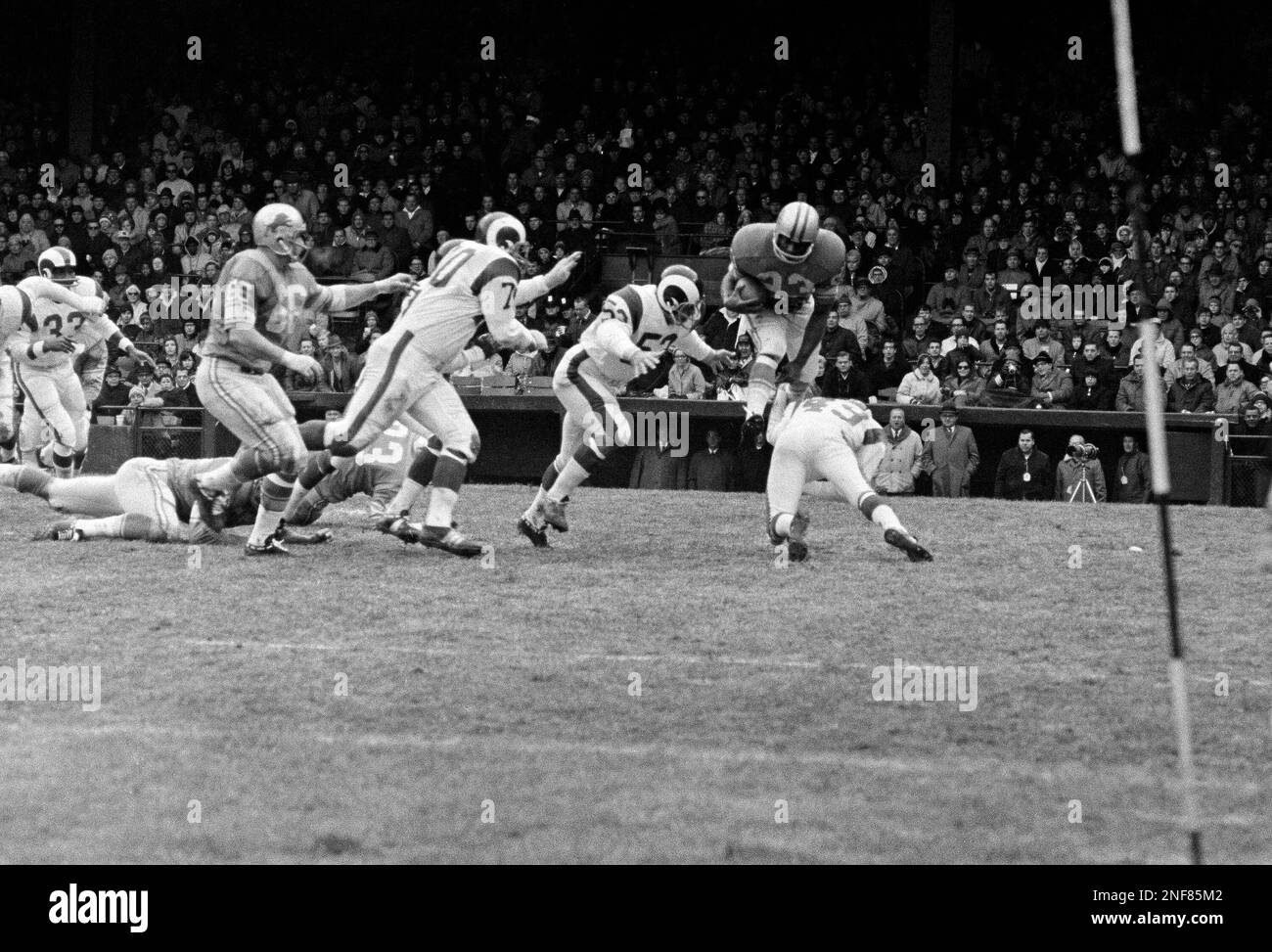 Detroit Lions’ back Tom Watkins tries to skip over the back of Los ...