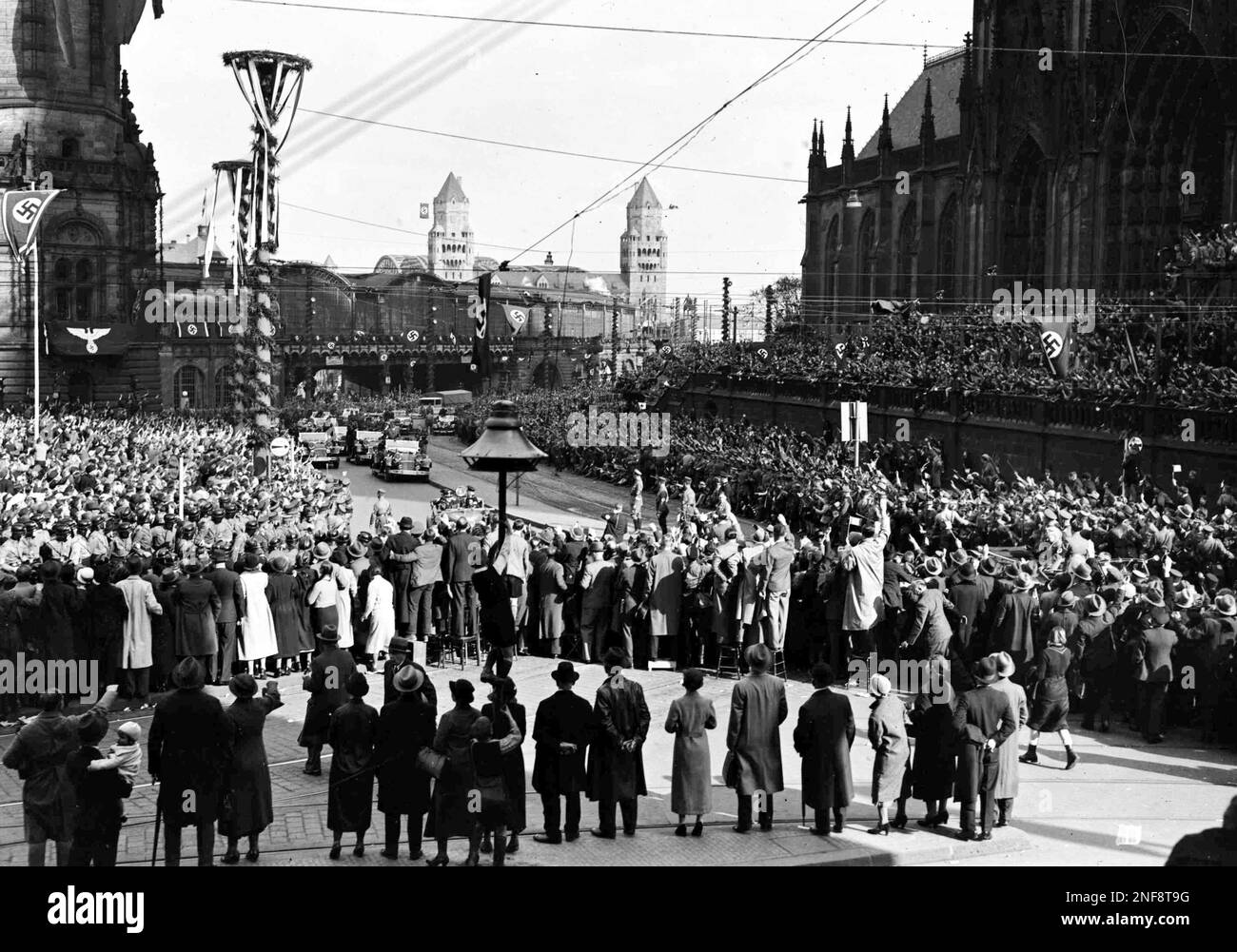 German Chancellor Adolf Hitler stands in his car and acknowledges the ...