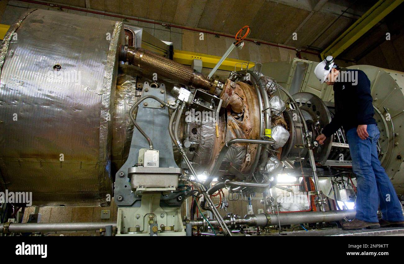 Technician Franck Boulet inspects a turbojet engine used to compress ...