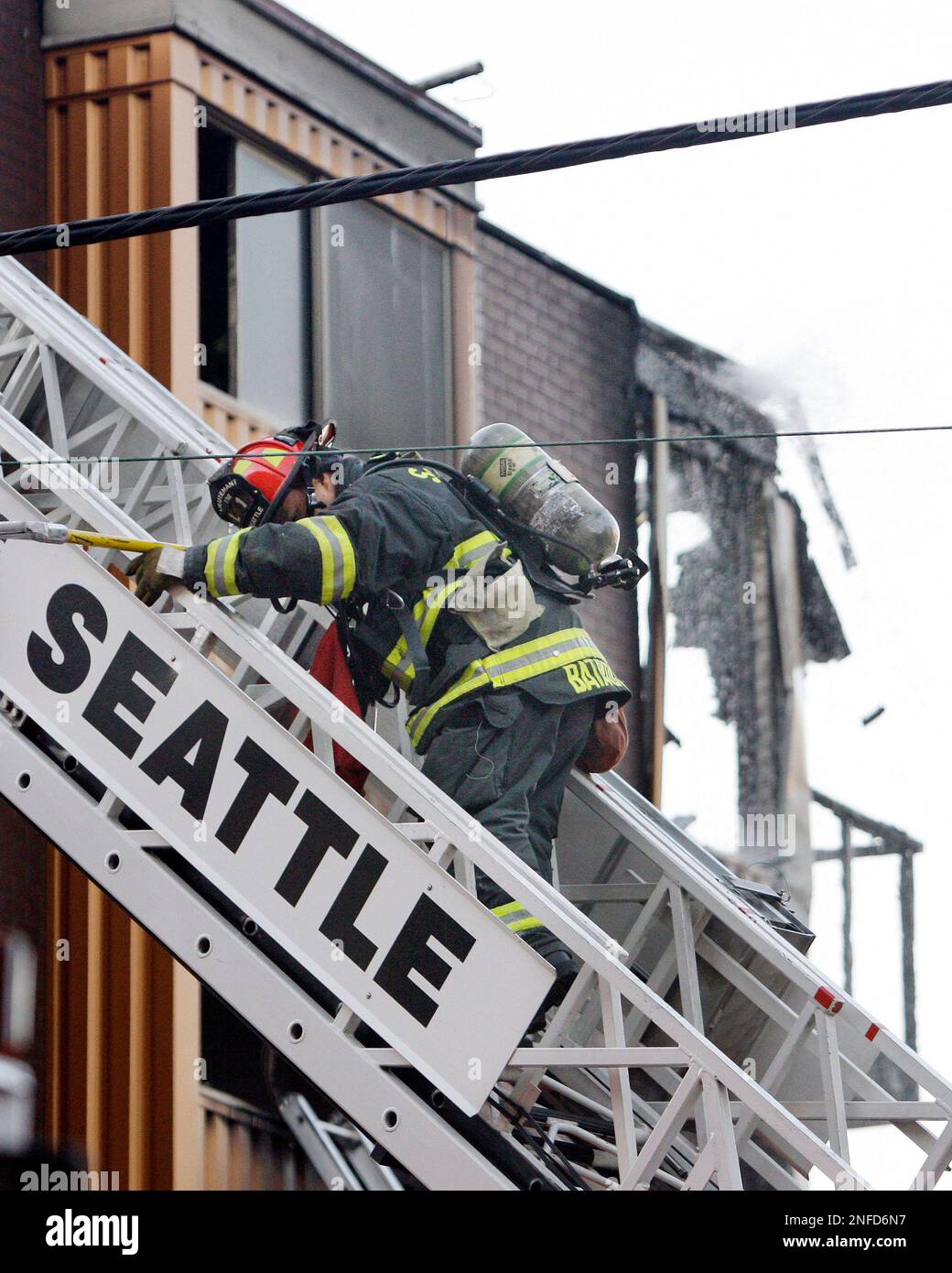 A firefighter climbs down a ladder at the scene of a fatal fire Monday ...