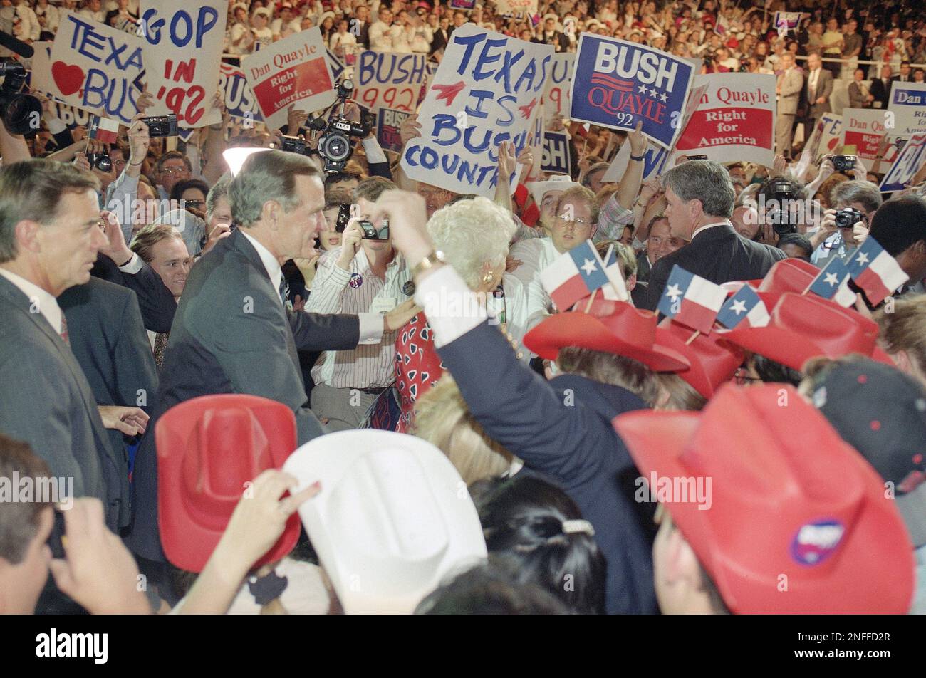 President George Bush and his wife Barbara are surrounded by a crowd ...