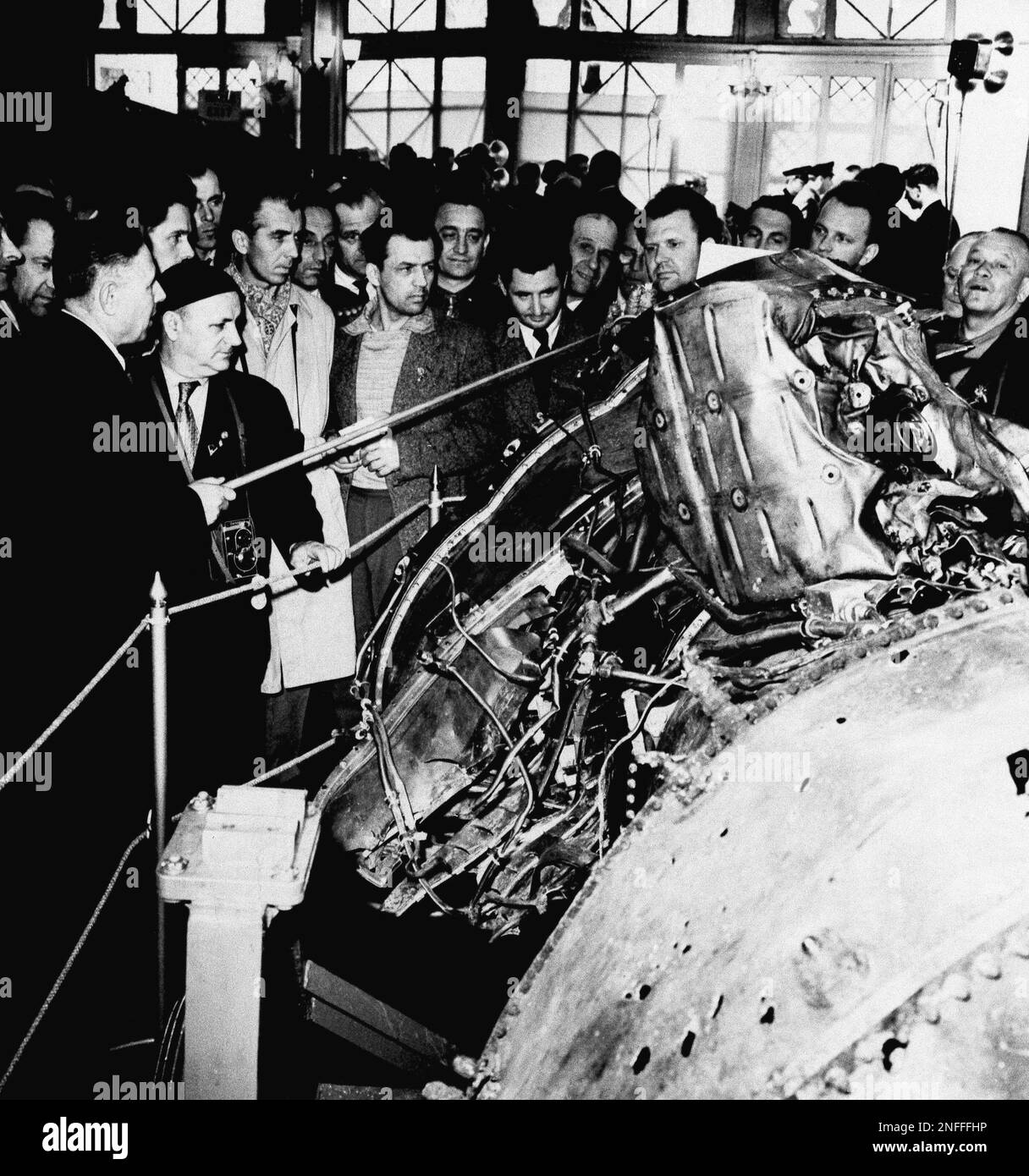 An engineer expert demonstrating to the visitors the engine of the ...