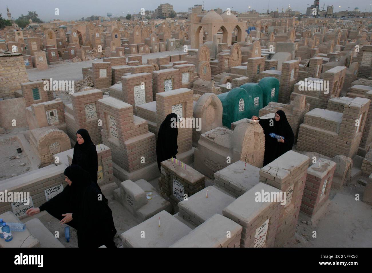 Relatives light candles and recite verses of the Holy Quran as they pay their respects to the ...
