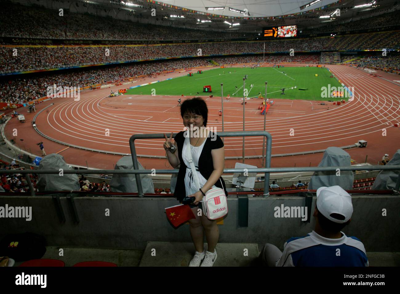 A Chinese spectator poses for a snapshot inside the National Stadium ...
