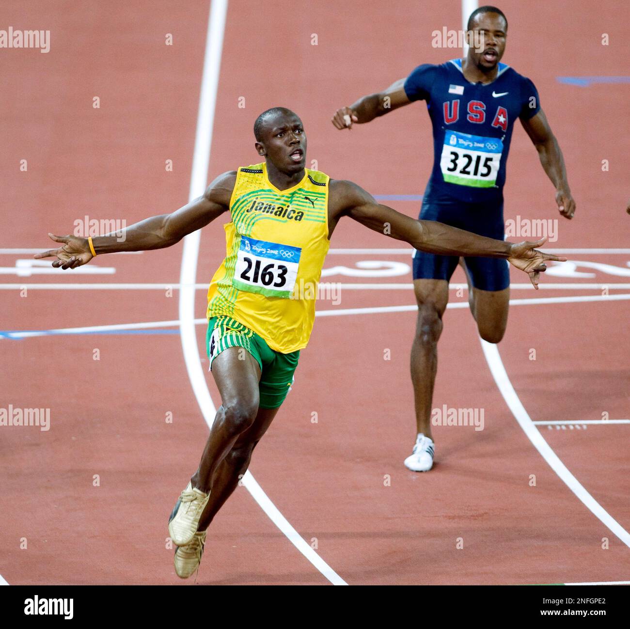 Usain Bolt, from, Jamaica, gestures as he crosses the finish time ...