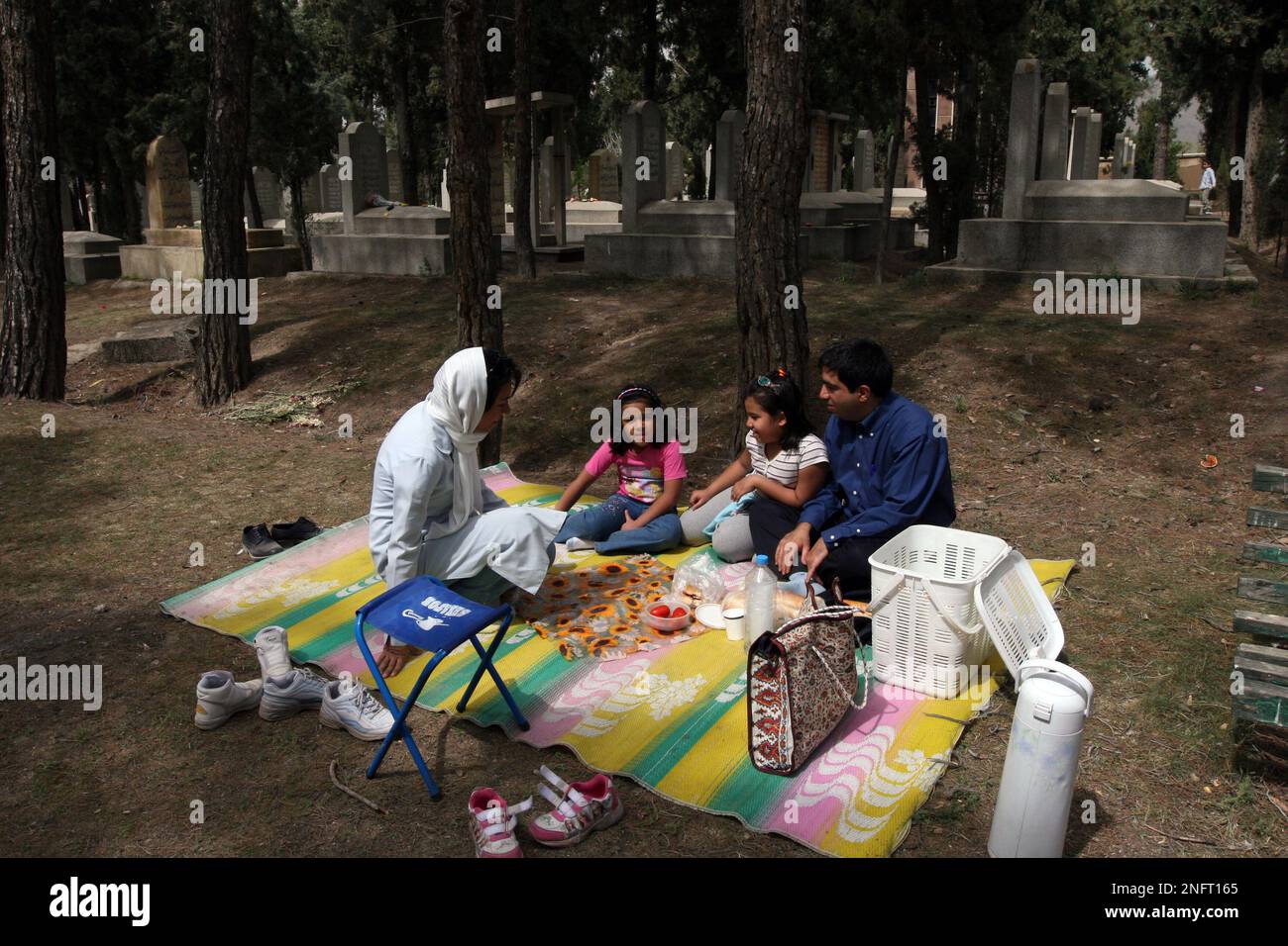 An Iranian Zoroastrian family spend their time during a ceremony for ...