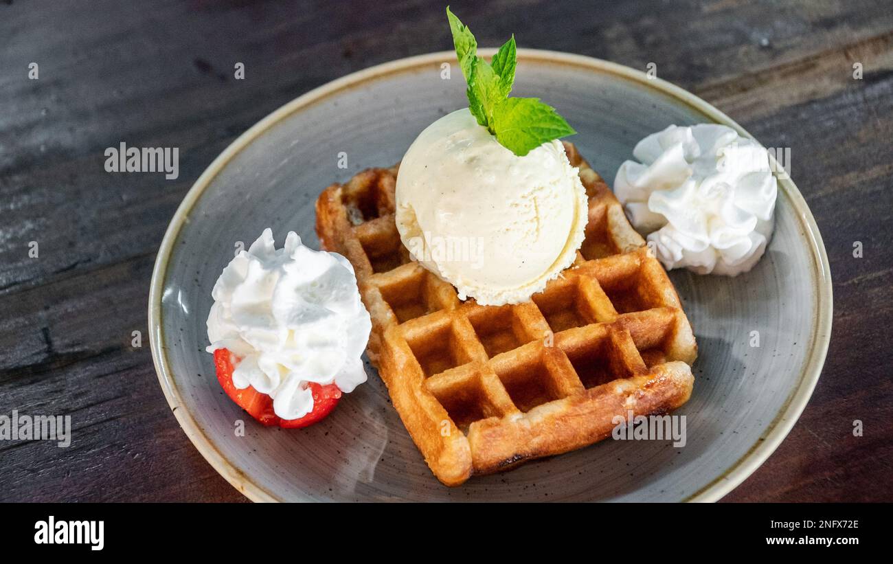 Ein Bild einer frisch zubereiteten Waffel, begleitet von Schlagsahne ...