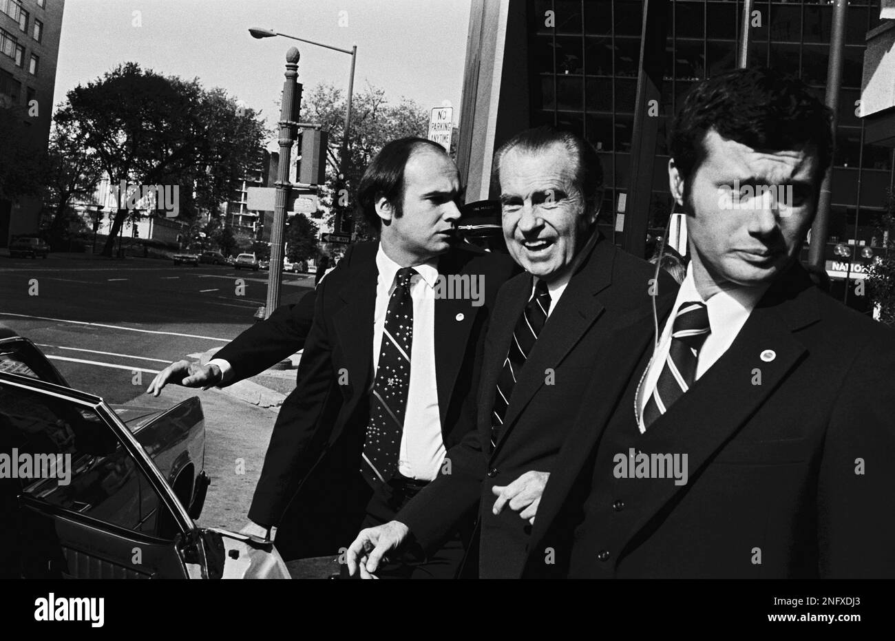 Former President Richard Nixon standing behind a secret service agent ...