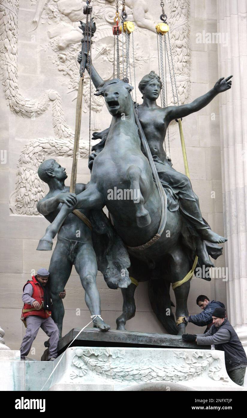 Restoration workers set up a sculpture at the entrance of the Palais de ...