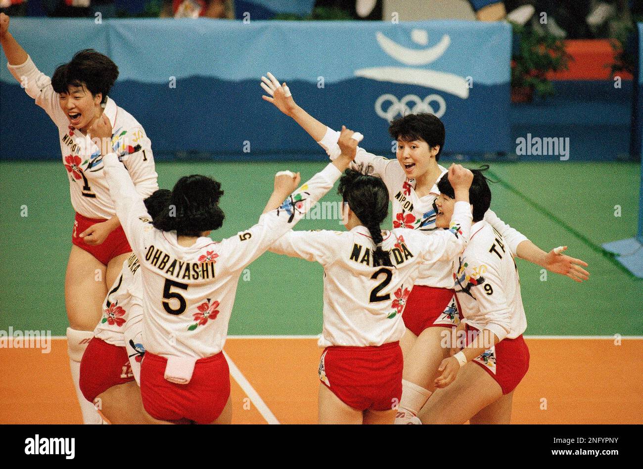 Members of the Japanese volleyball team celebrate their victory over ...