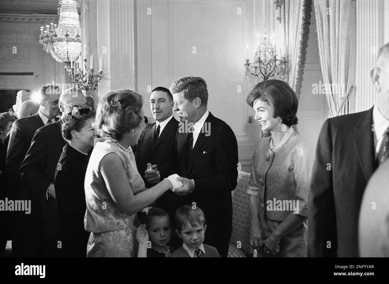 President John Kennedy, stands in the receiving line between his wife ...