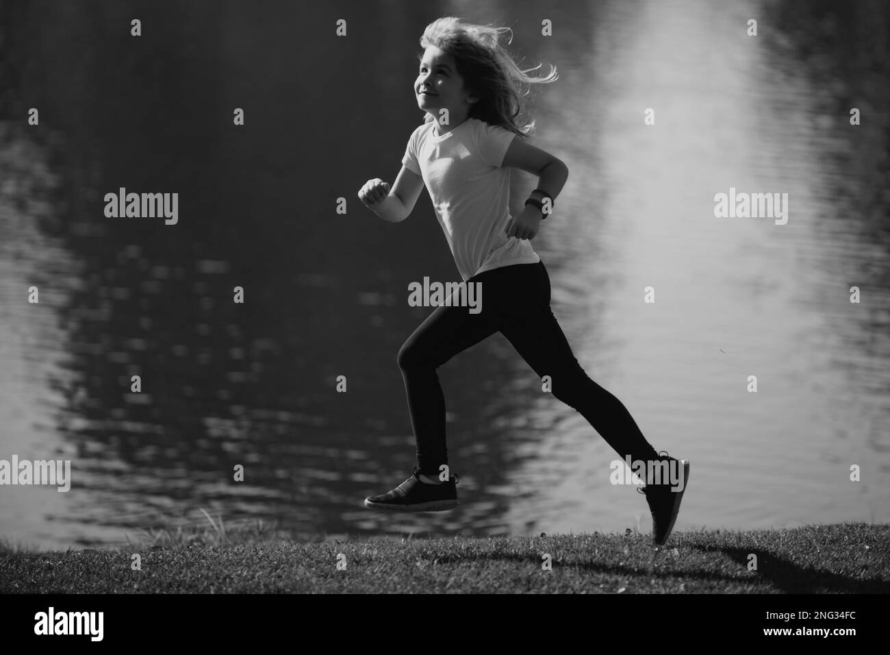Kinder joggen im Park im Freien. Kleiner Junge, der in der Natur läuft ...