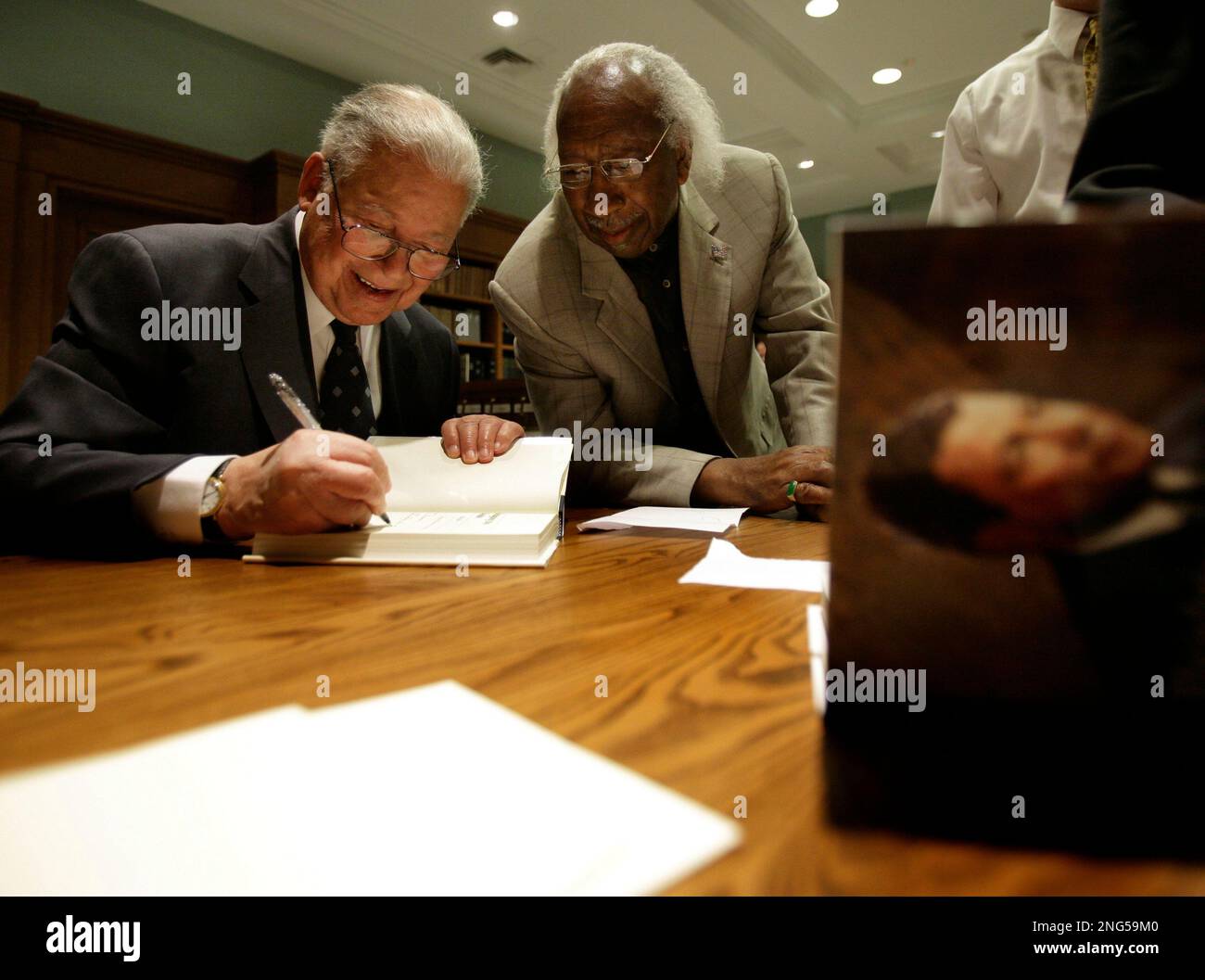 Former Sen. Edward W. Brooke, 86, left, signs a copy of his book ...