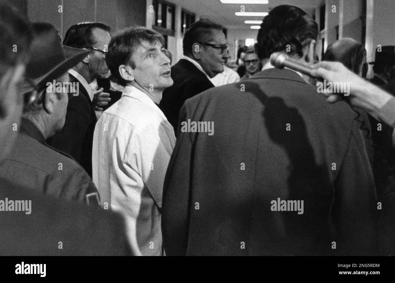 Convicted murderer Gary Gilmore surrounded by deputies and other guards ...