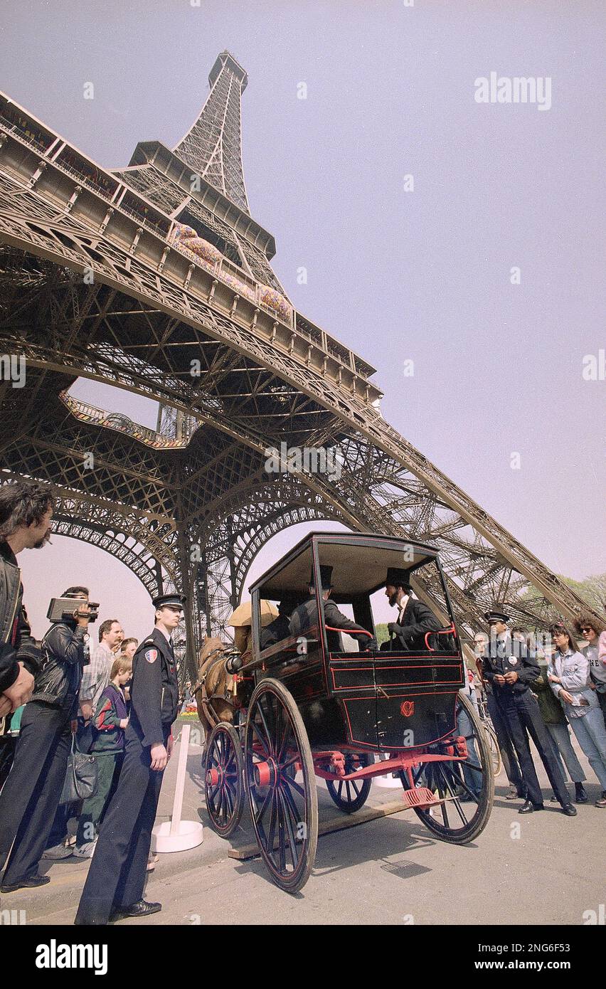 French actors dressed in late 19th century costumes ride in a horse ...