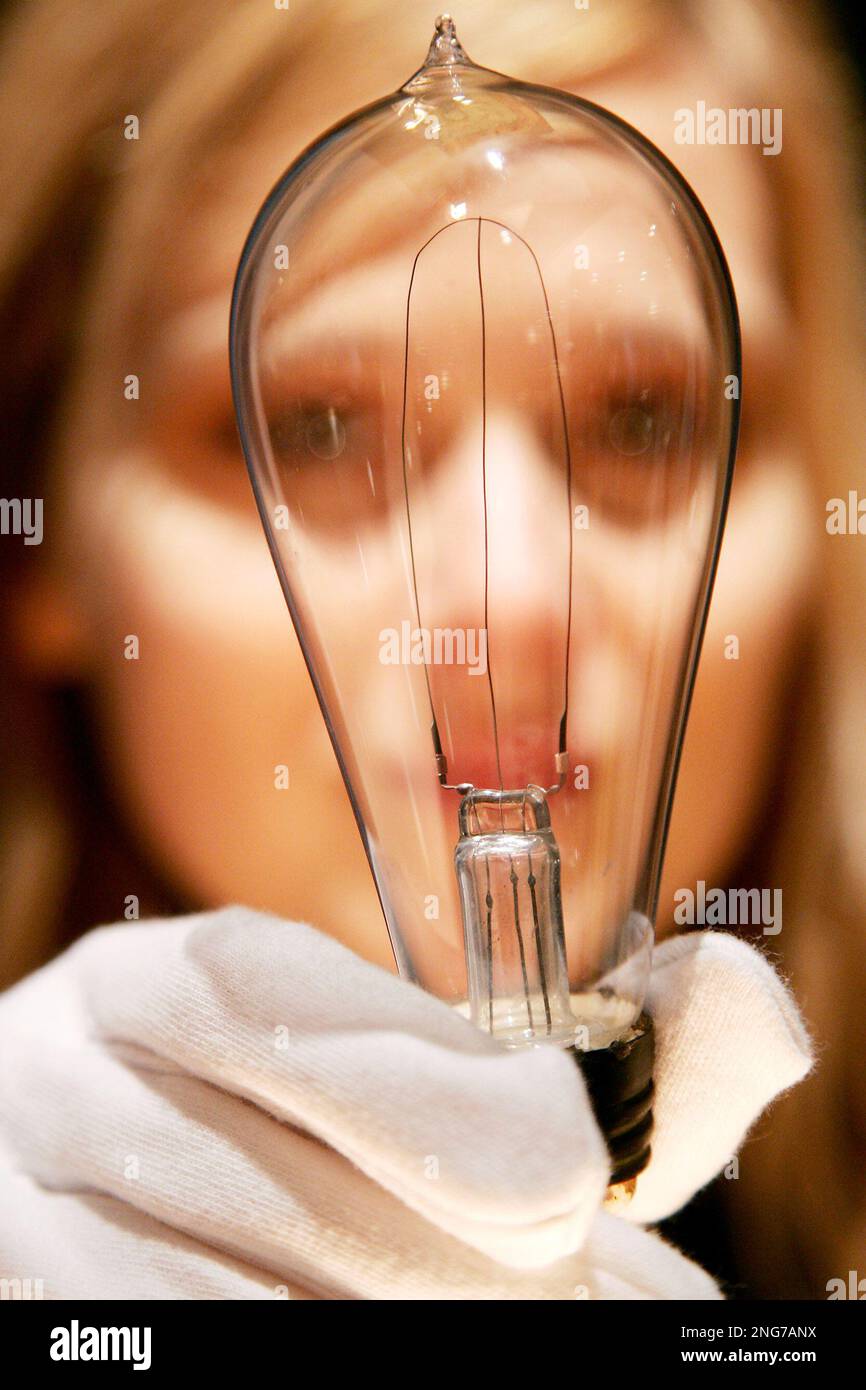 A staff member at Christie's shows off the 1883 Edison Effect Lamp ...